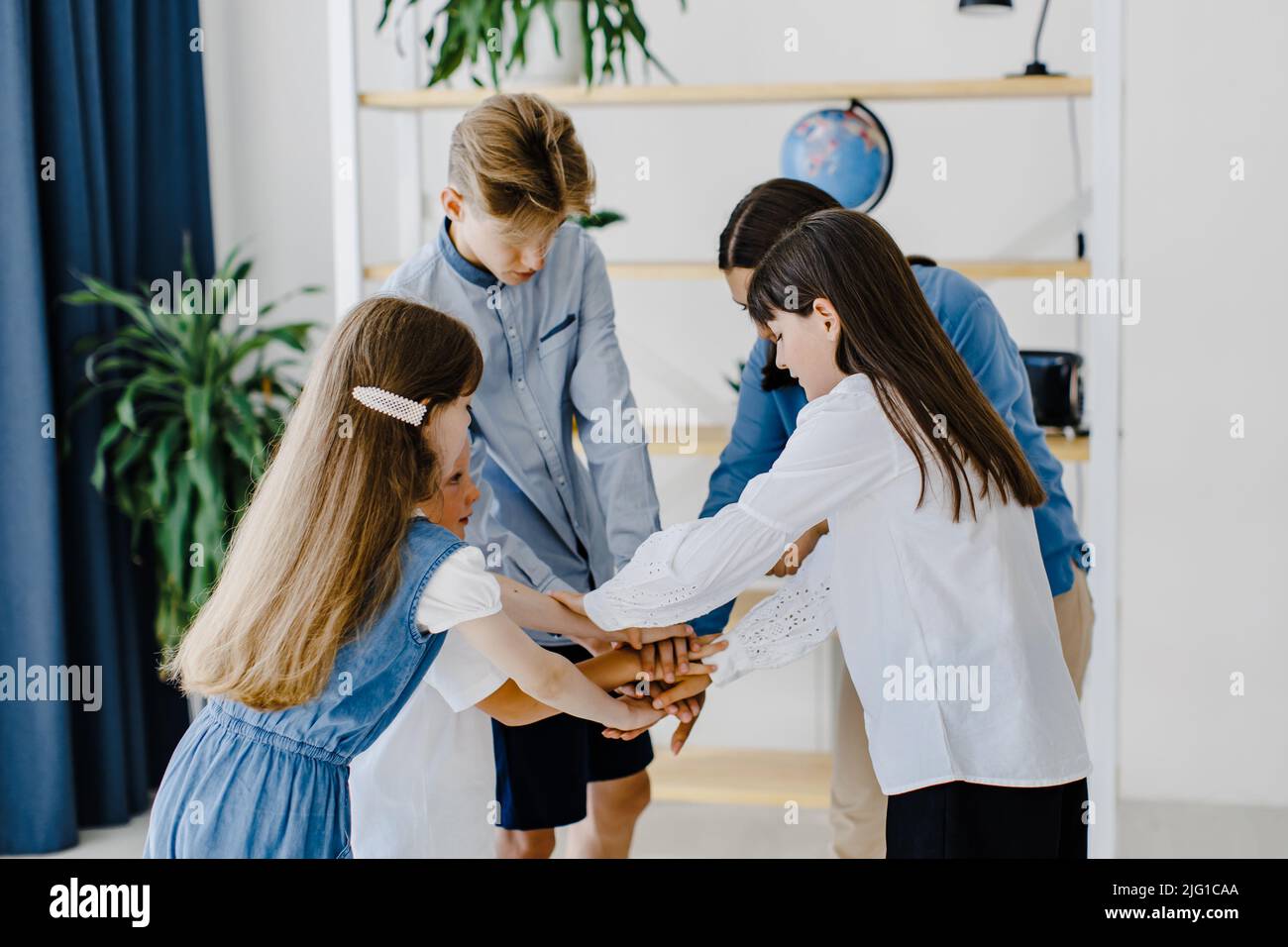 Side view. Woman with his kids students in holding hands for success ...