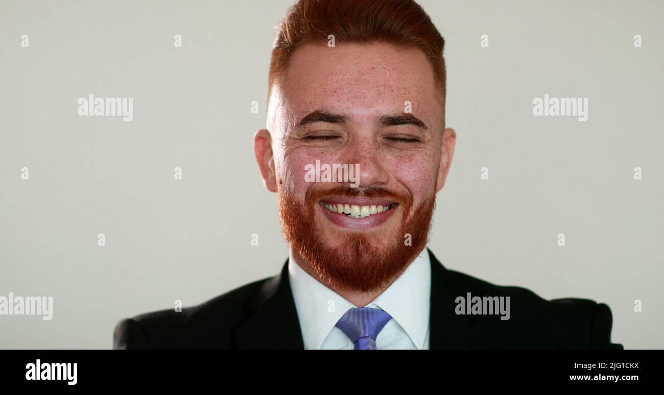 Spontaneous real life smile and laugh. Handsome redhead man smiling and ...