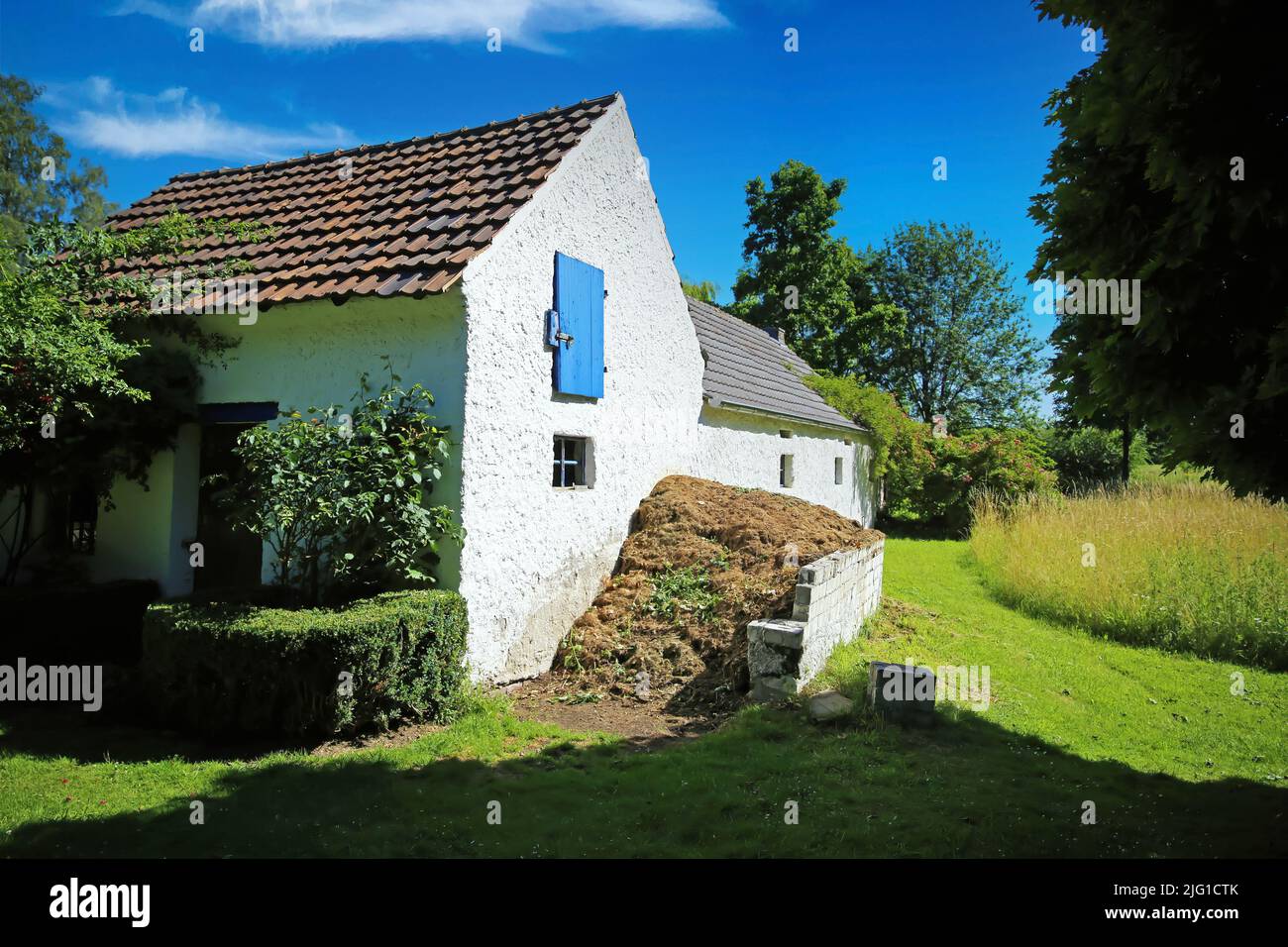 Idyllic white old german farm house, dung heap, blue summer sky, green ...