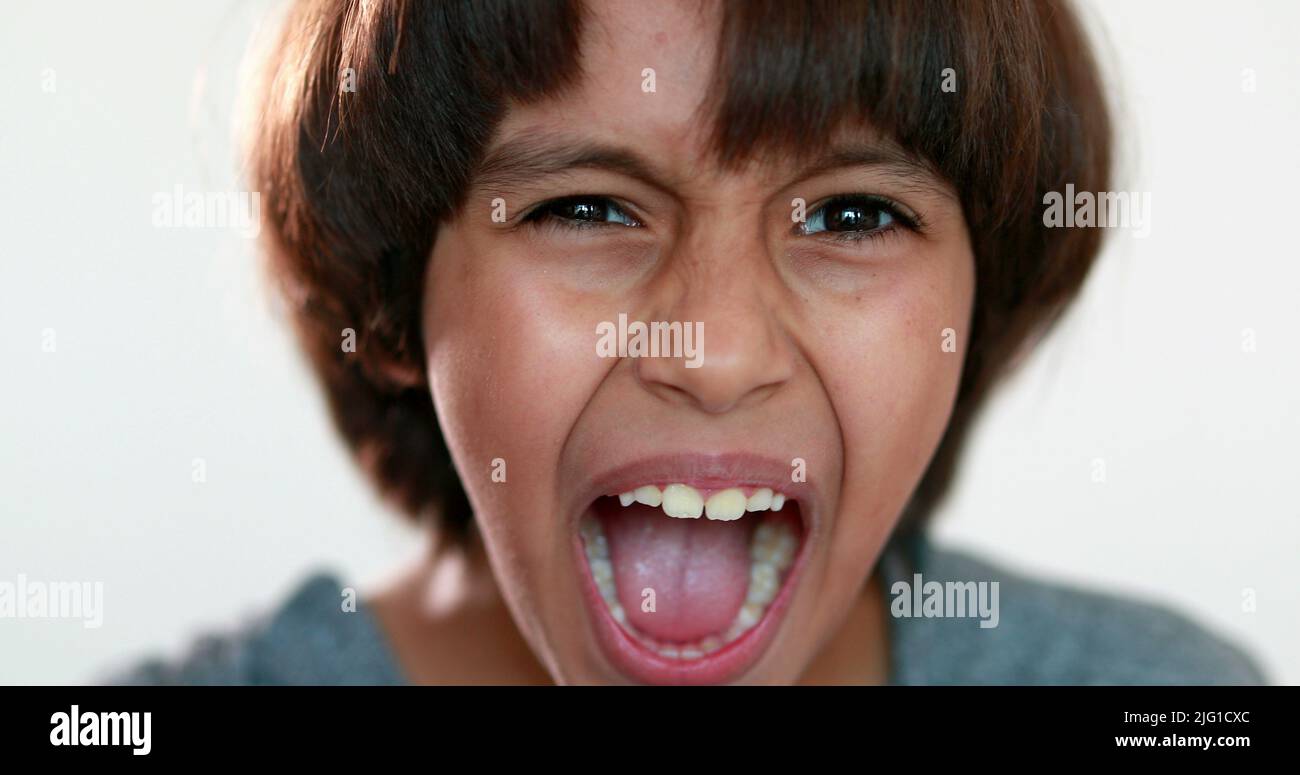Upset child screaming. Mixed race Kid yelling roaring to camera, close ...
