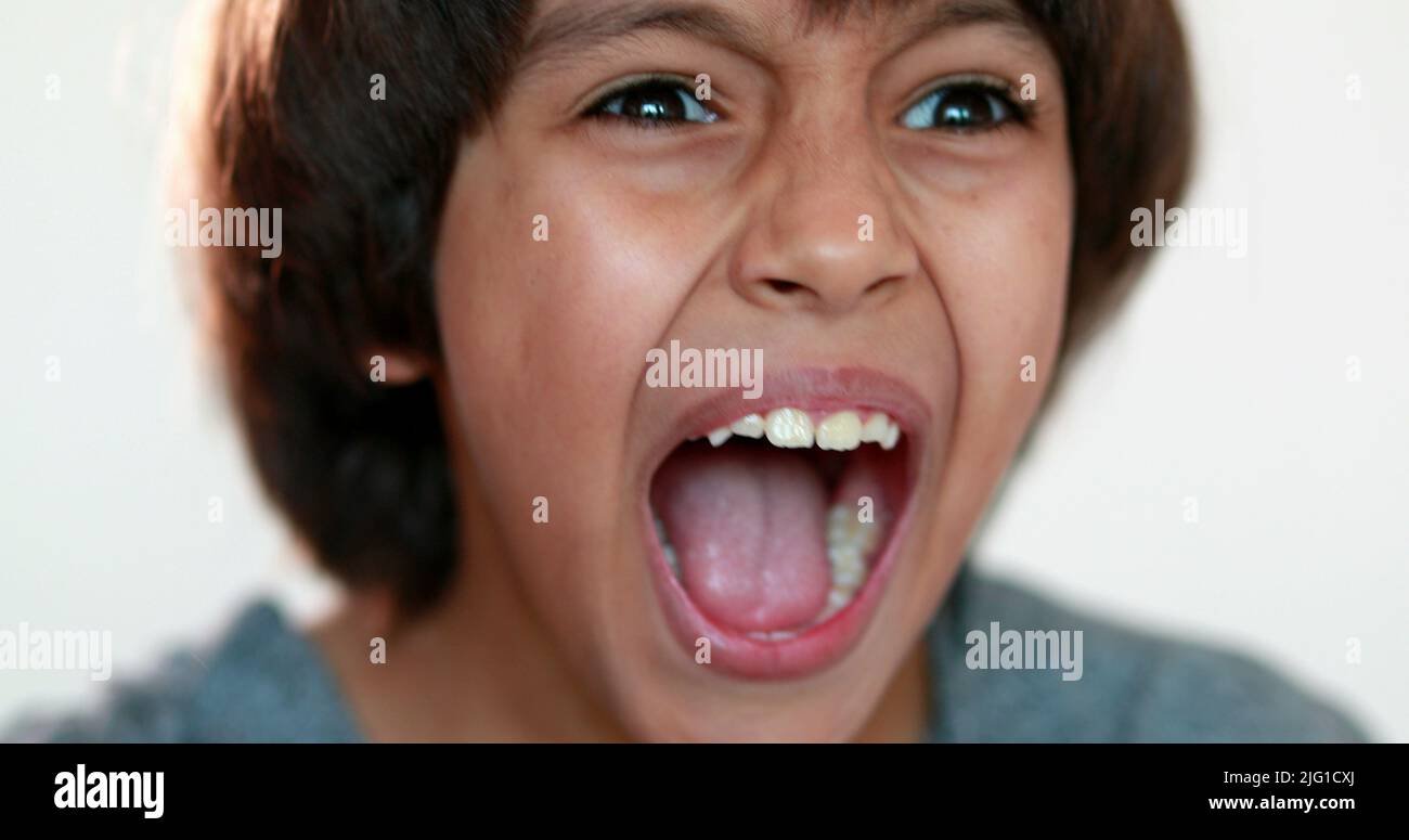 Upset child screaming. Mixed race Kid yelling roaring to camera, close-up angry boy face Stock ...