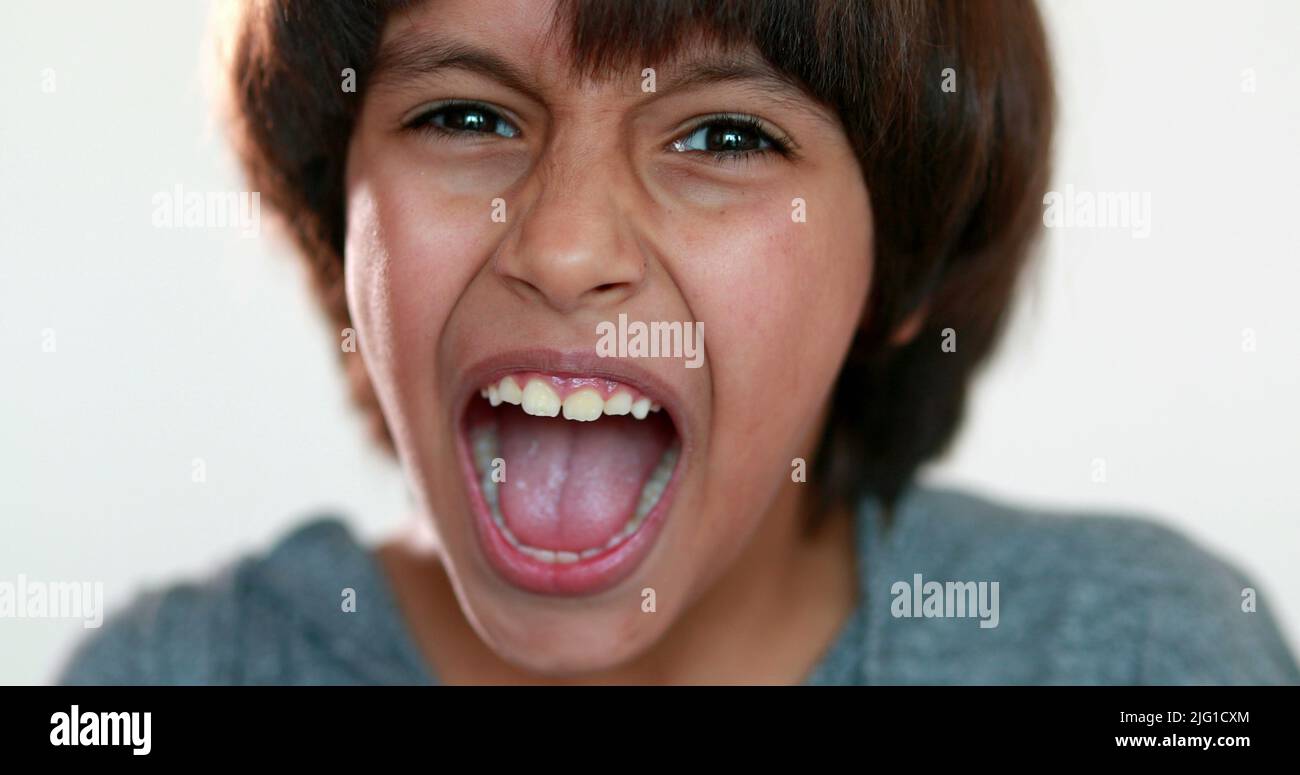 Upset child screaming. Mixed race Kid yelling roaring to camera, close-up angry boy face Stock ...