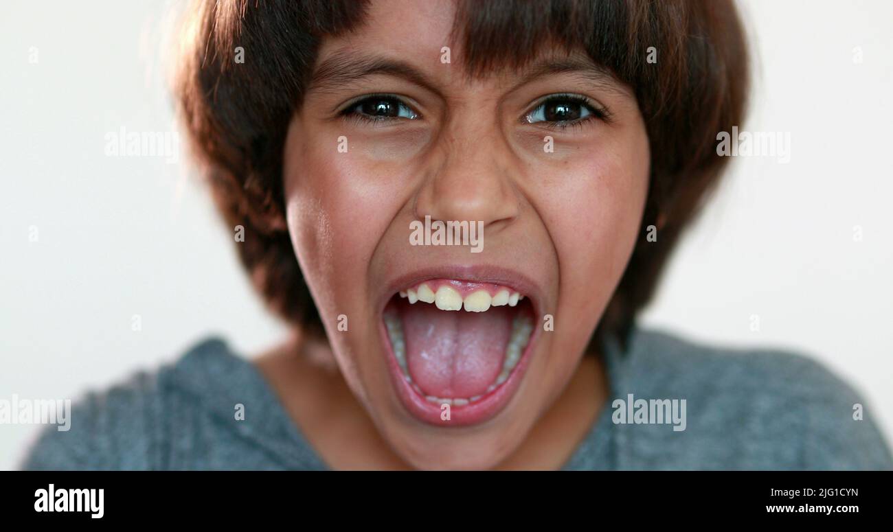 Upset child screaming. Mixed race Kid yelling roaring to camera, close ...
