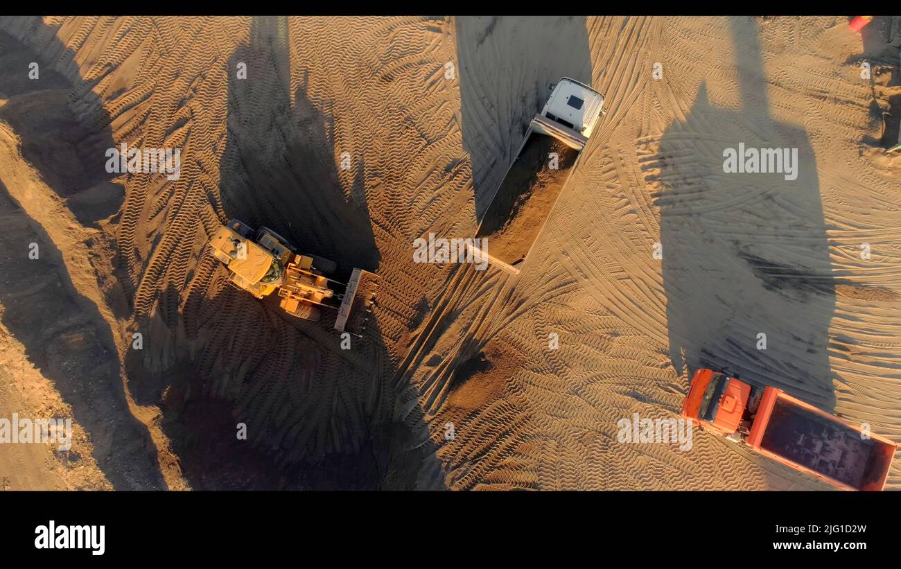 Bird's-eye view. Scene.Large trucks on an empty desert terrain ...