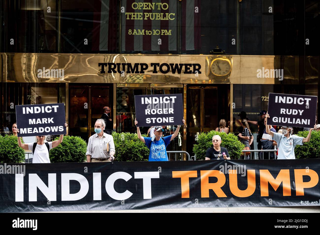 People holding signs saying "Indict Mark Meadows", "Indict Roger Stone ...