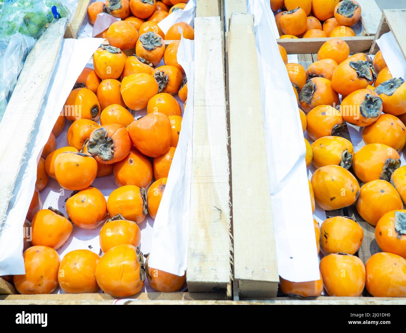 Honey persimmon on the counter. Sale of fruits in the store. Lots of ...