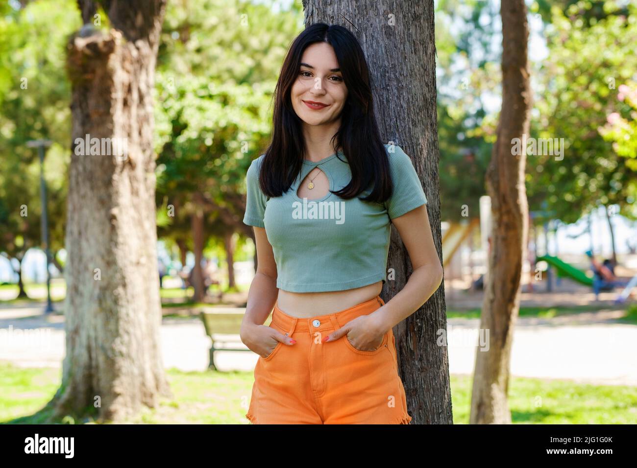Cute caucasian woman wearing turquoise tee on city park, outdoors woman ...