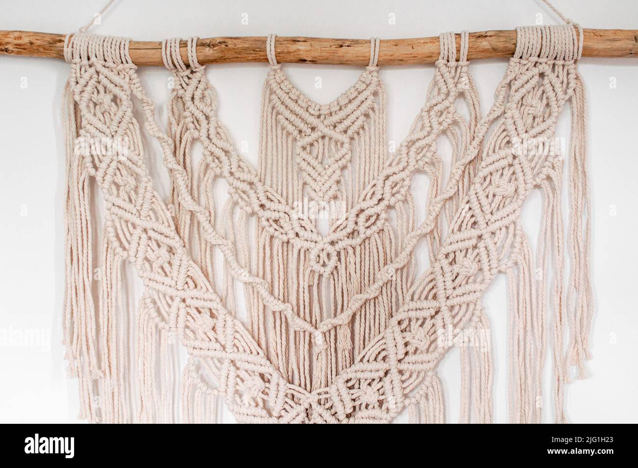 wall decor of woven threads in the style of macrame on a white ...
