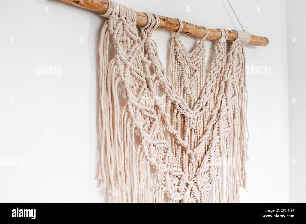 wall decor of woven threads in the style of macrame on a white ...