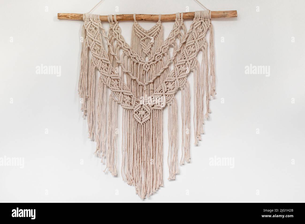 Wall decor of woven threads in style of macrame on a white background ...
