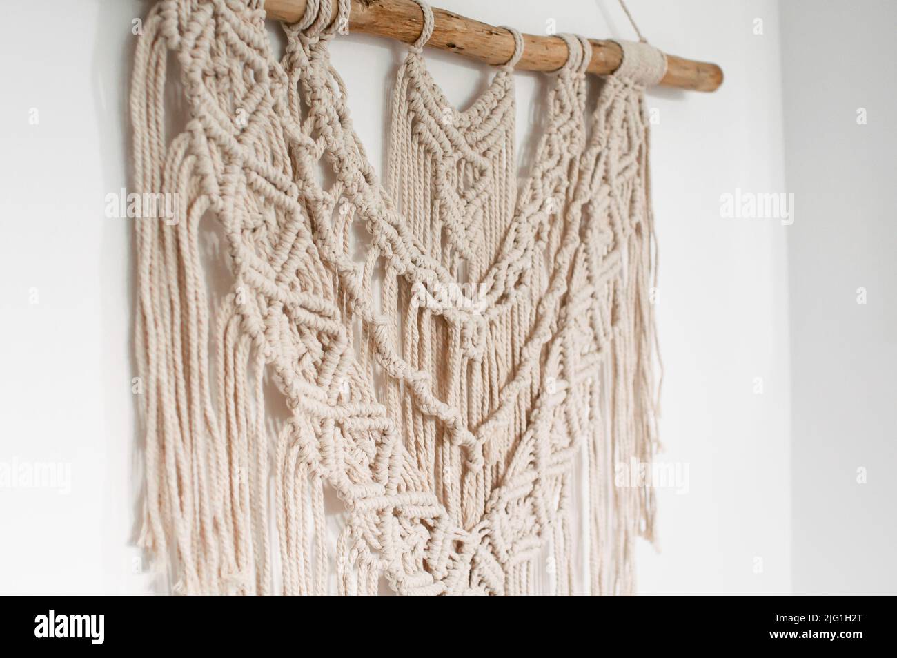 Fragment wall decor made of woven threads in macrame style on white ...