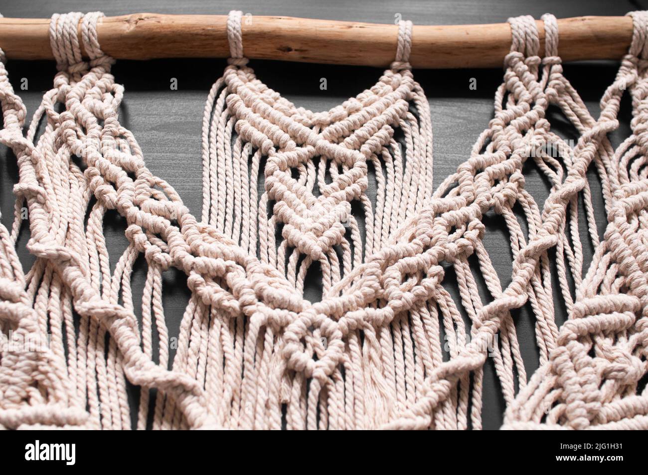 fragment of a wall decor made of woven threads in the style of macrame ...