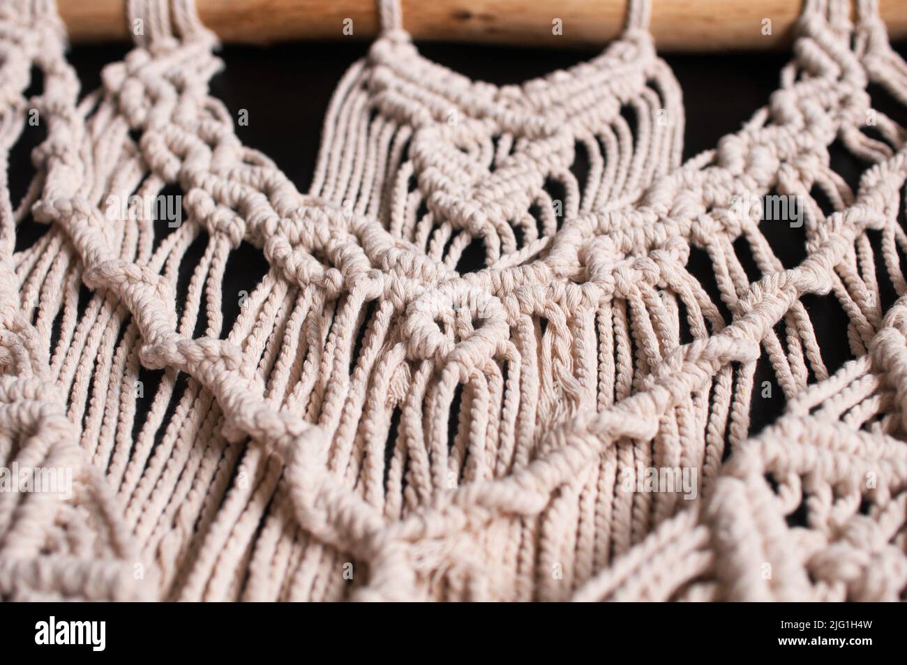 fragment of a wall decor made of woven threads in the style of macrame ...