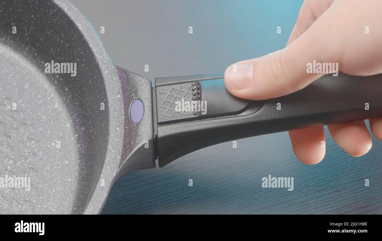 Close up of new frying pan with removable handle. Action. Concept of ...