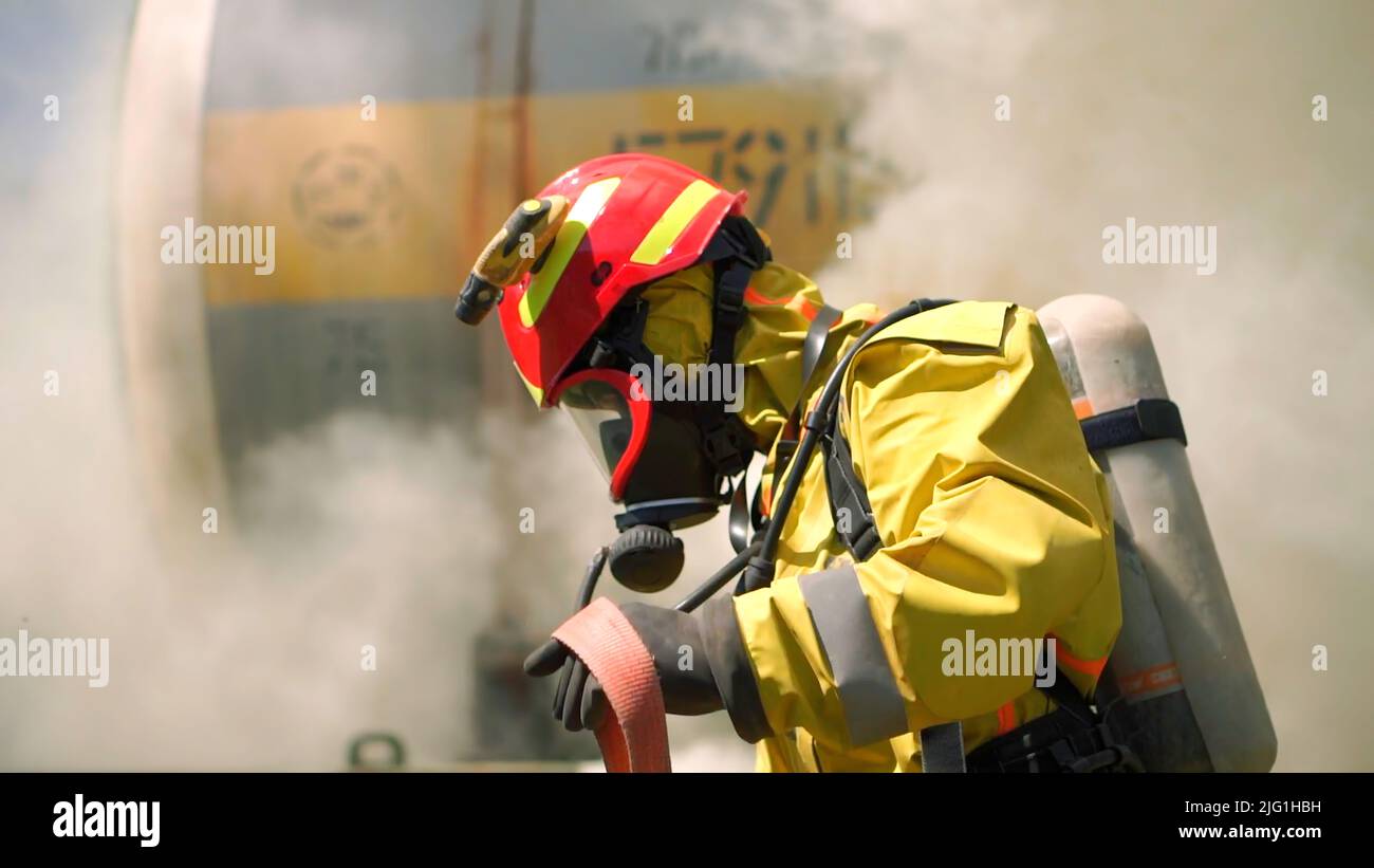 Male firefighter in the helmets and uniform with smoke on the ...