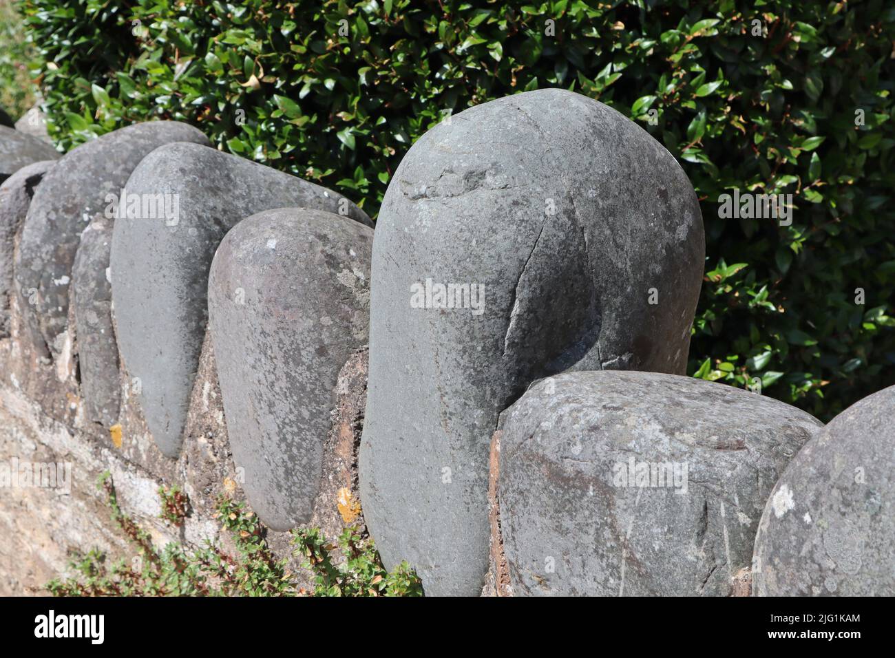 Large round stones cemented to the top of a wall as an ornamental ...