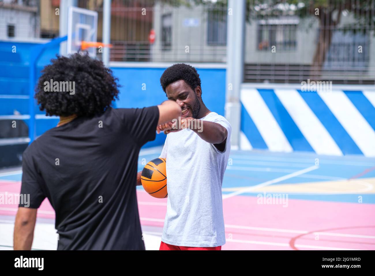 Two friends greeting each other on a colorful basketball court Stock ...