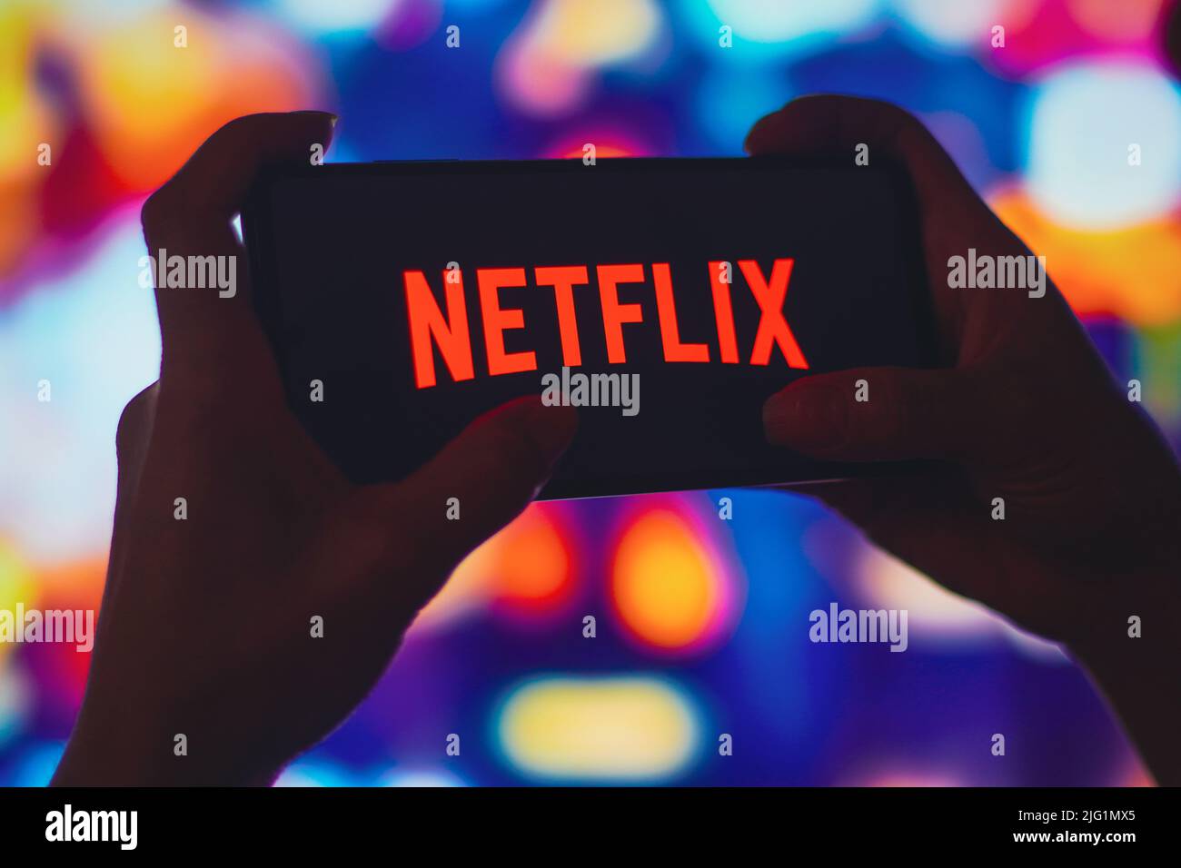 In this photo illustration, a silhouetted woman holds a smartphone with ...