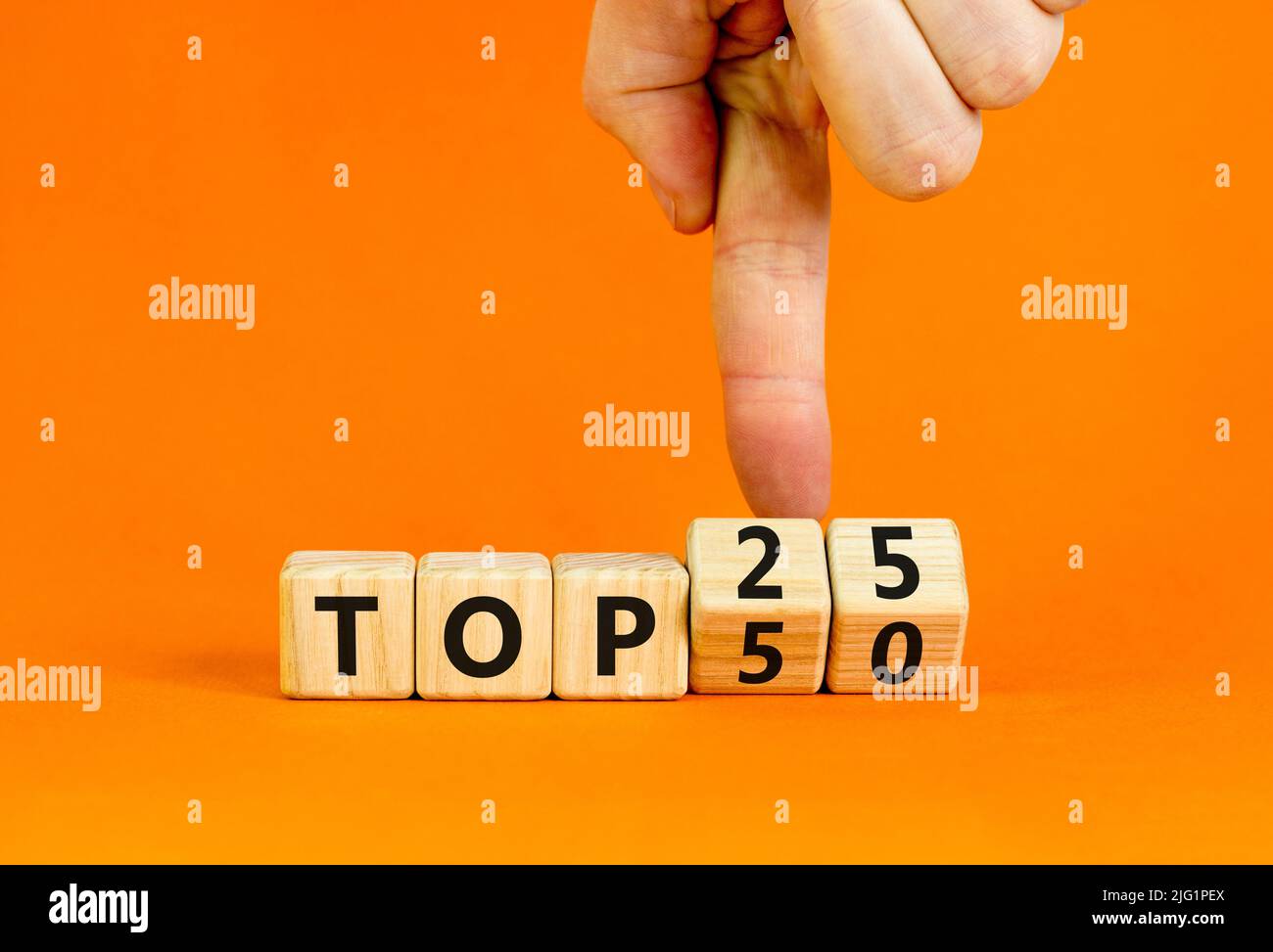 From Top 50 to 25 symbol. Businessman turns wooden cubes and changes ...