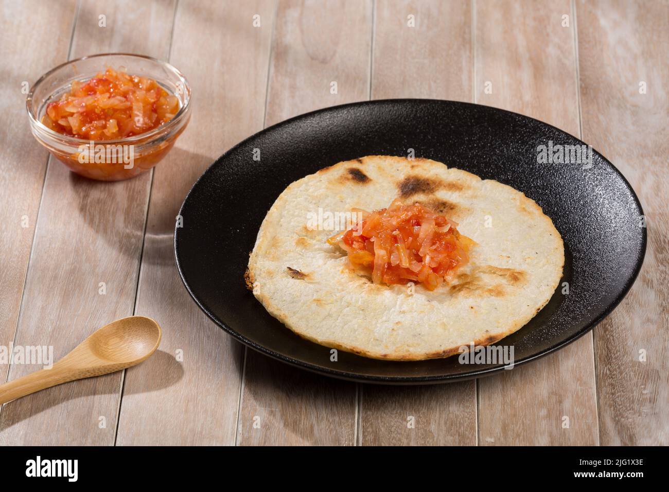 White corn arepa with hogao - tasty Colombian breakfast Stock Photo - Alamy