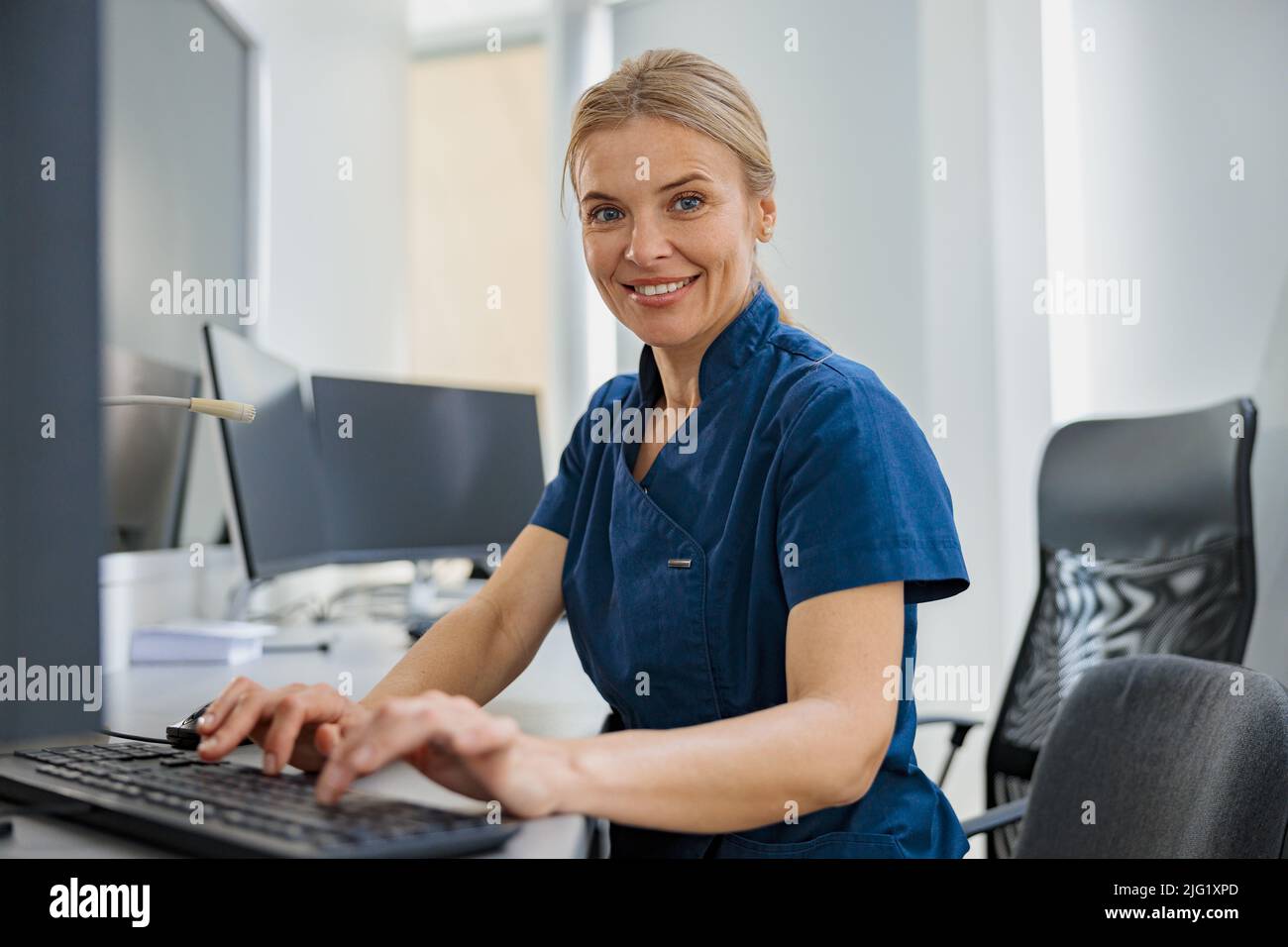 Nurse on Duty working on computer at the Reception Desk in modern ...