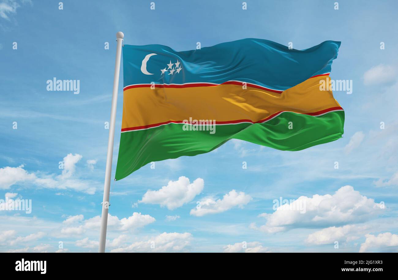 official flag of Karakalpakstan at cloudy sky background on sunset ...