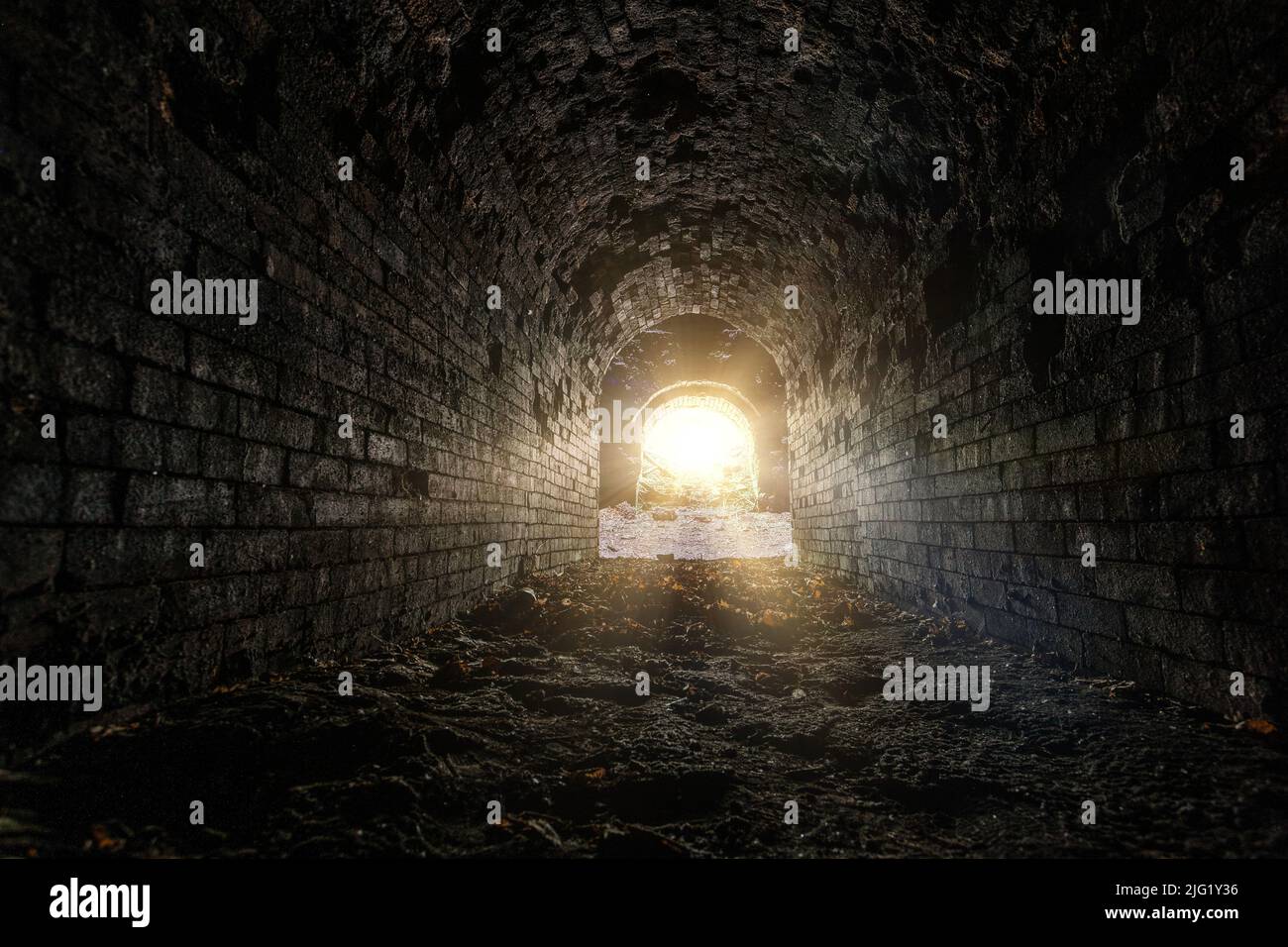 Historical underground red brick passage. Light at the end of tunnel ...