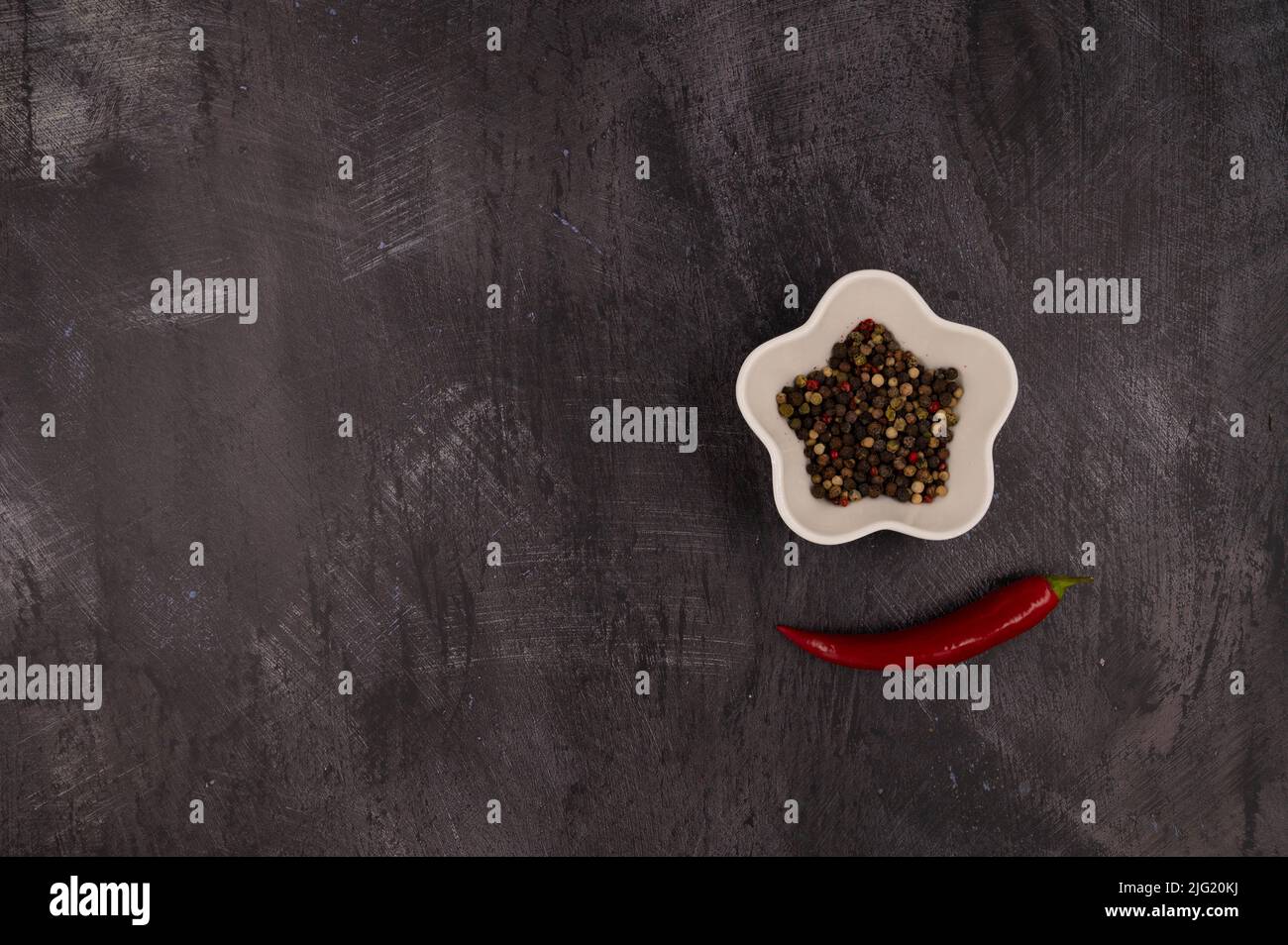 Aromatic colored peppers in a star-shaped container surrounded by red ...