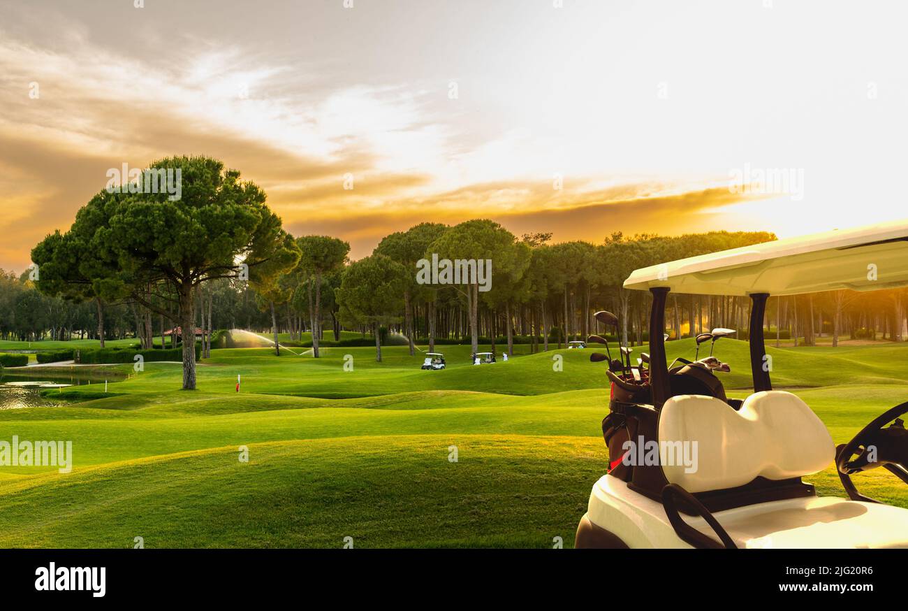Golf cart on beautiful golf course at sunset Stock Photo - Alamy