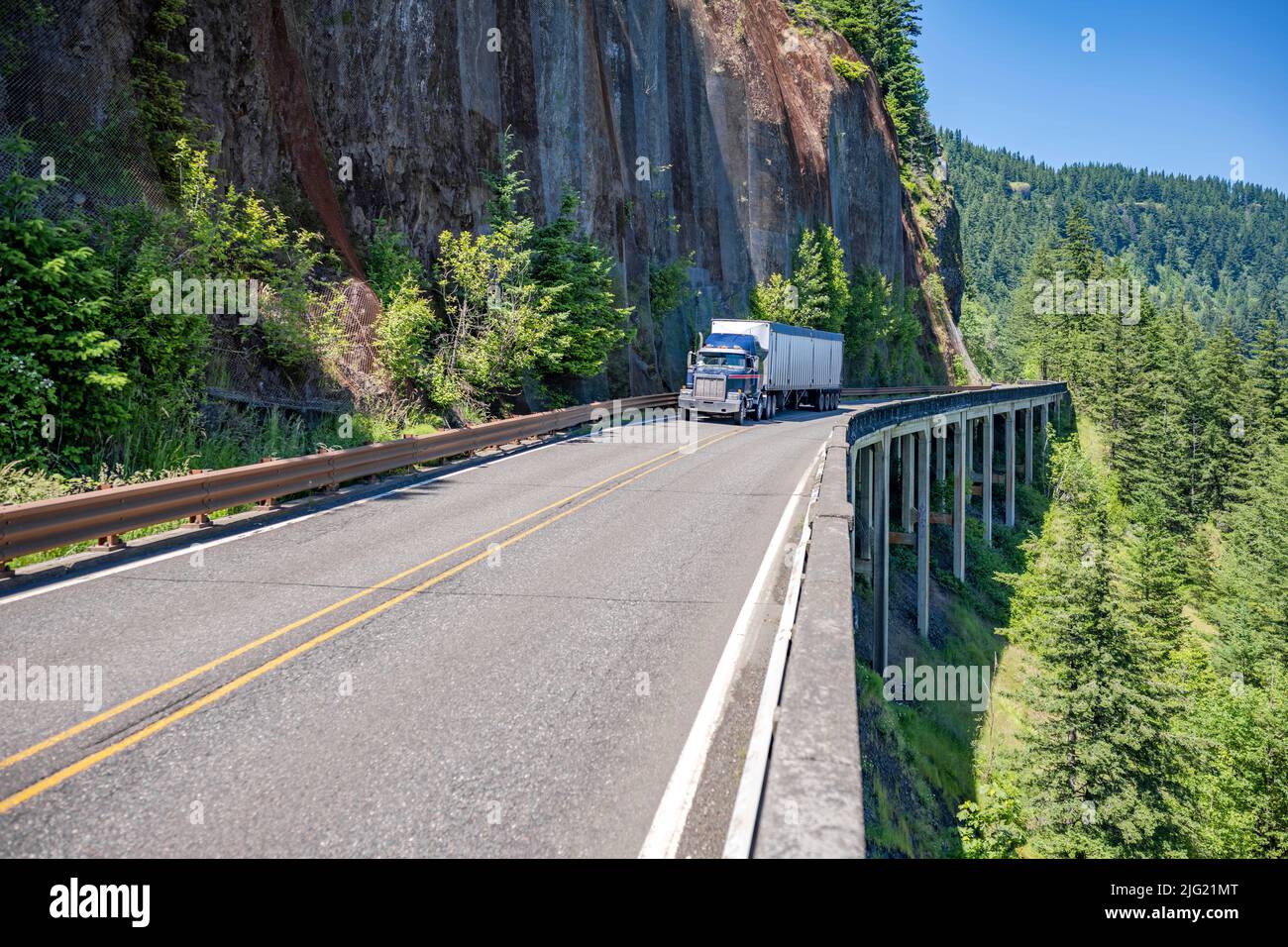 Powerful blue big rig semi truck tractor transporting cargo in bulk ...