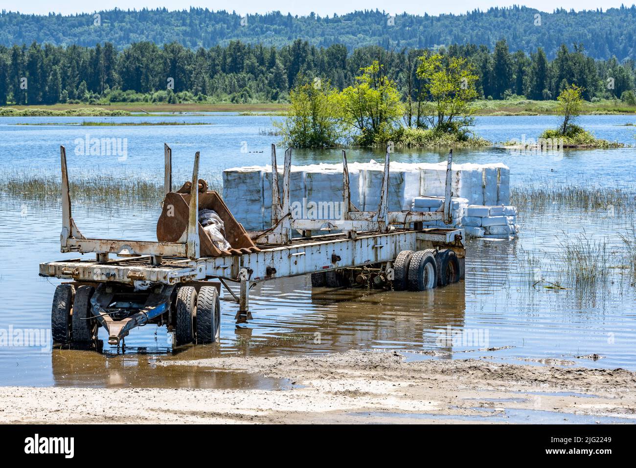 Sunken old rusty semi trailer and an unloaded stacked cargo standing in ...