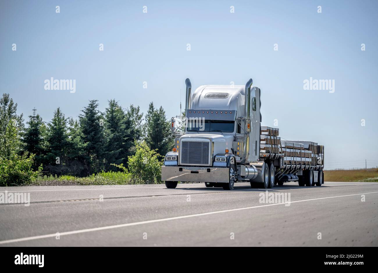 Industrial grade white classic big rig semi truck tractor transporting ...