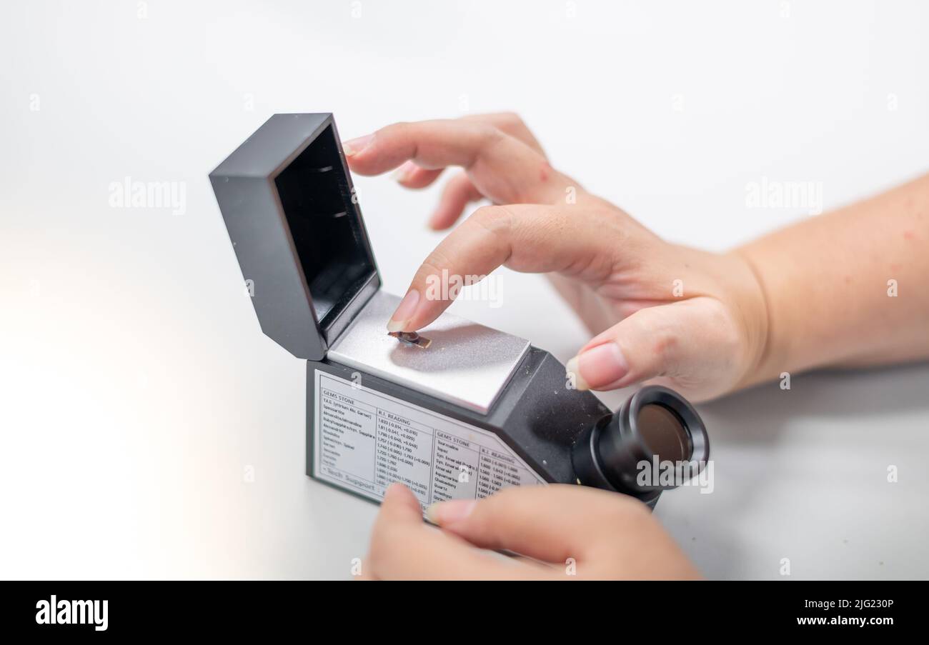 Female hand holding the precious stone for checking the specific of the ...