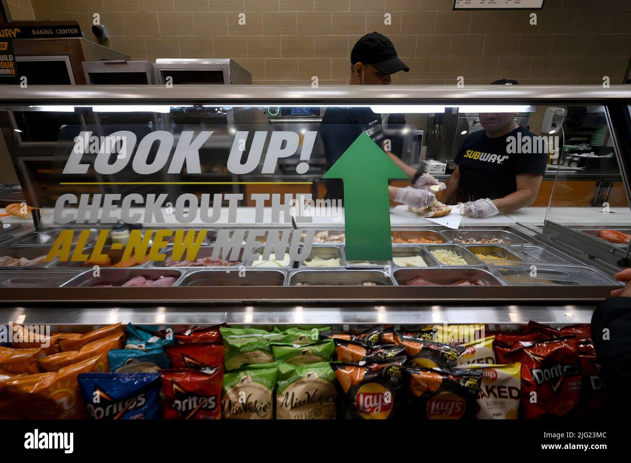 Subway Restaurant workers work in tandem to prepare a sandwich for a ...