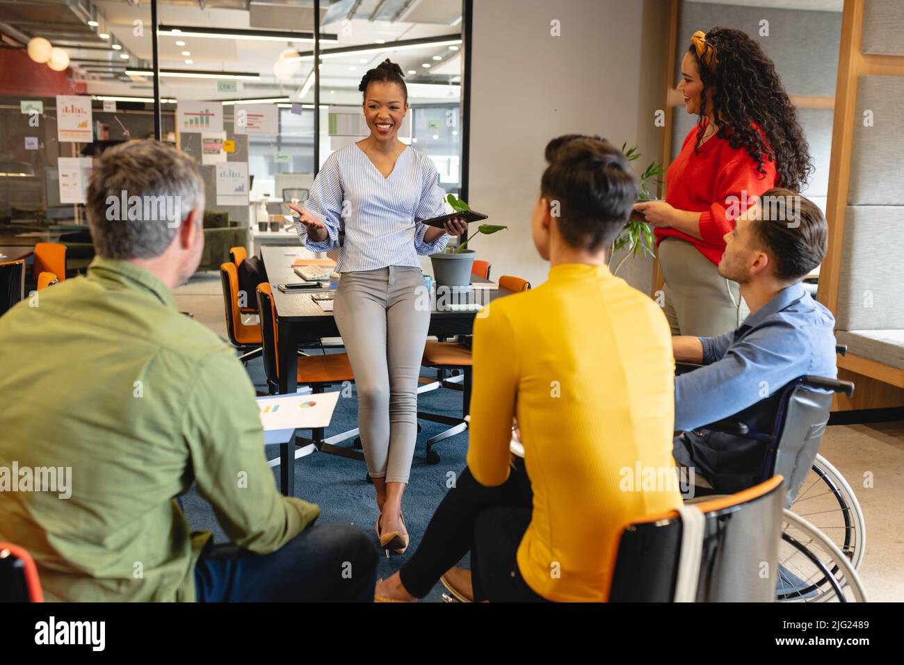 Happy african american female manager discussing with colleagues in ...