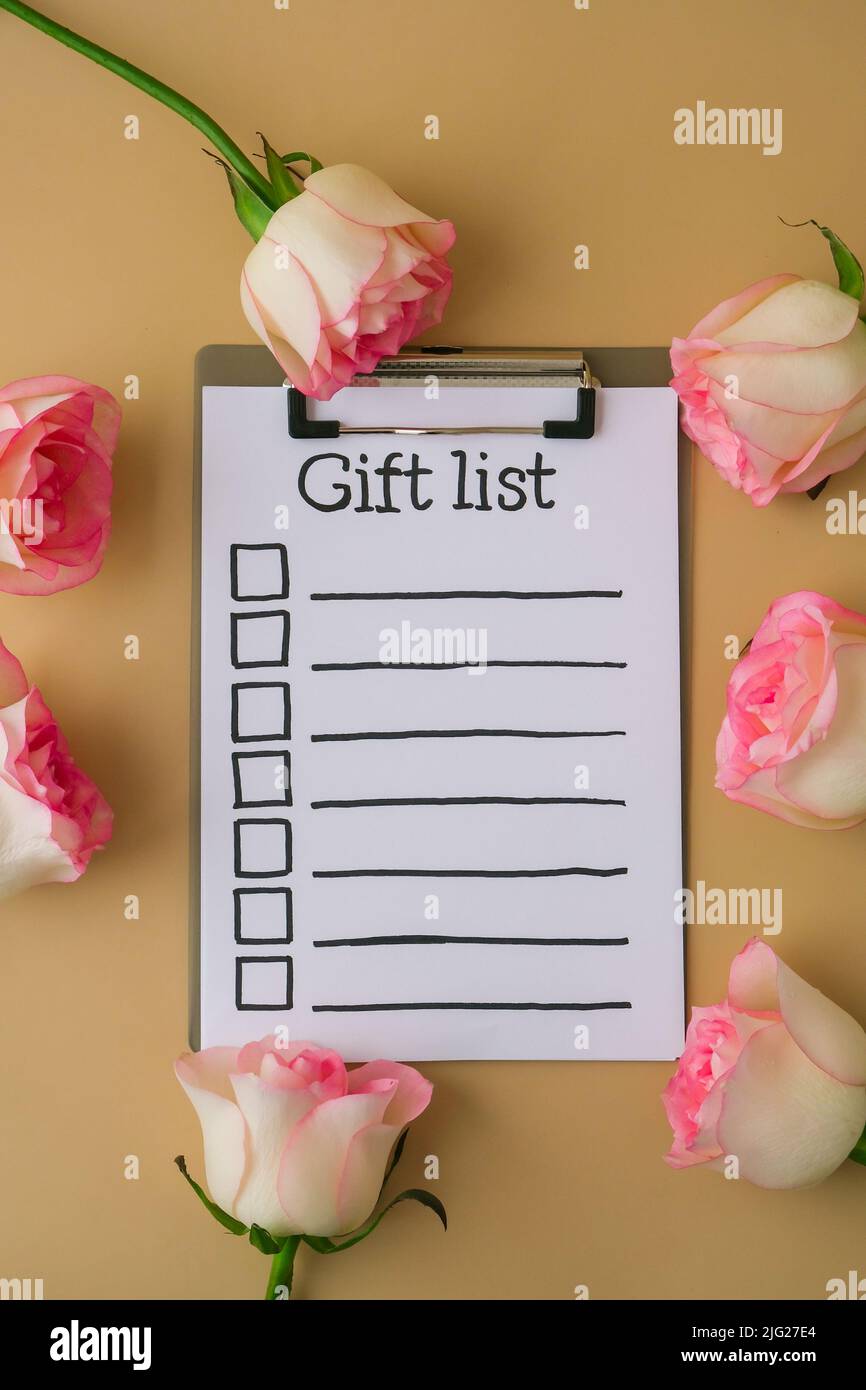 GIFT LIST text on paper note. Delicate pink roses on beige background ...
