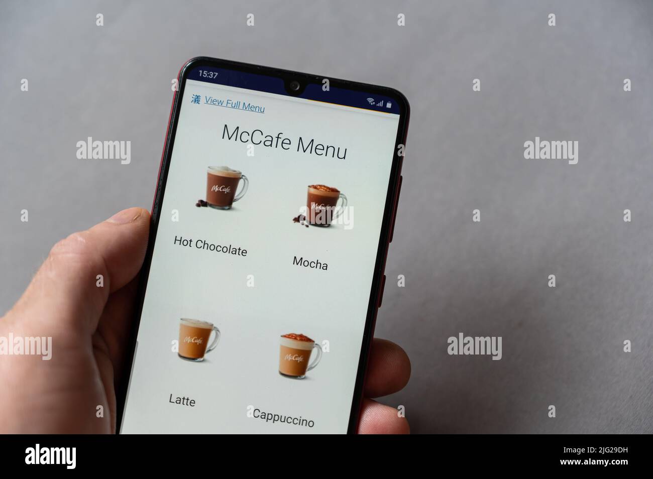 Smartphone with McCafe Menu. A man orders a drink at McDonald's ...