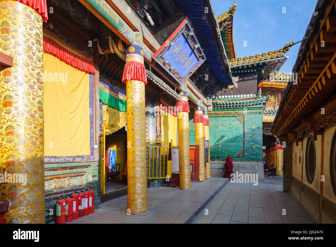 A monk walks past one of the temples in Ta'Er Monastery in Xining ...