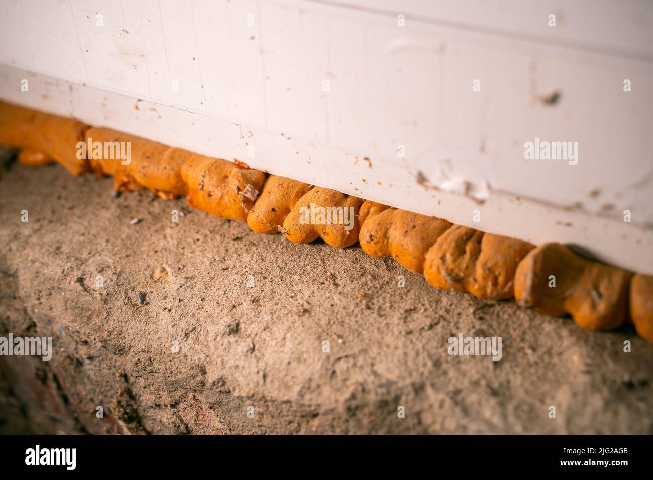 Old mounting foam between a plastic window and a brick wall close-up ...
