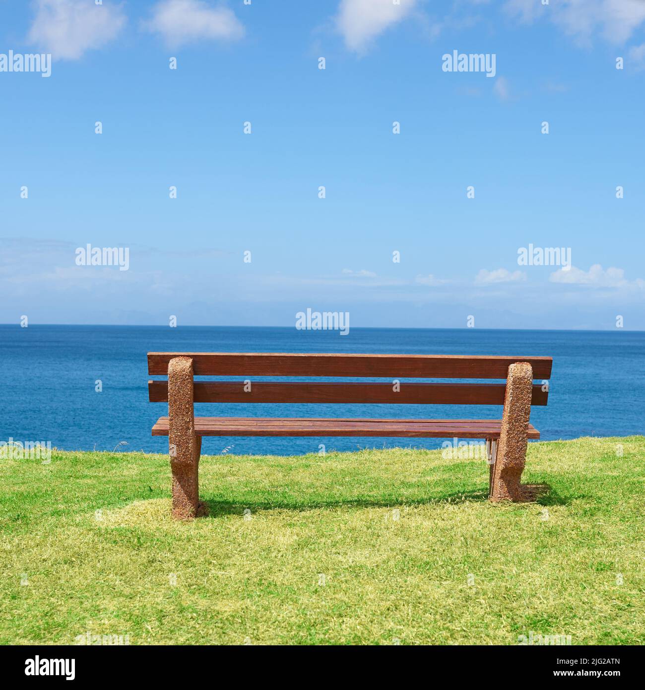 Empty bench overlooking the ocean on a sunny day with copyspace. Wooden ...