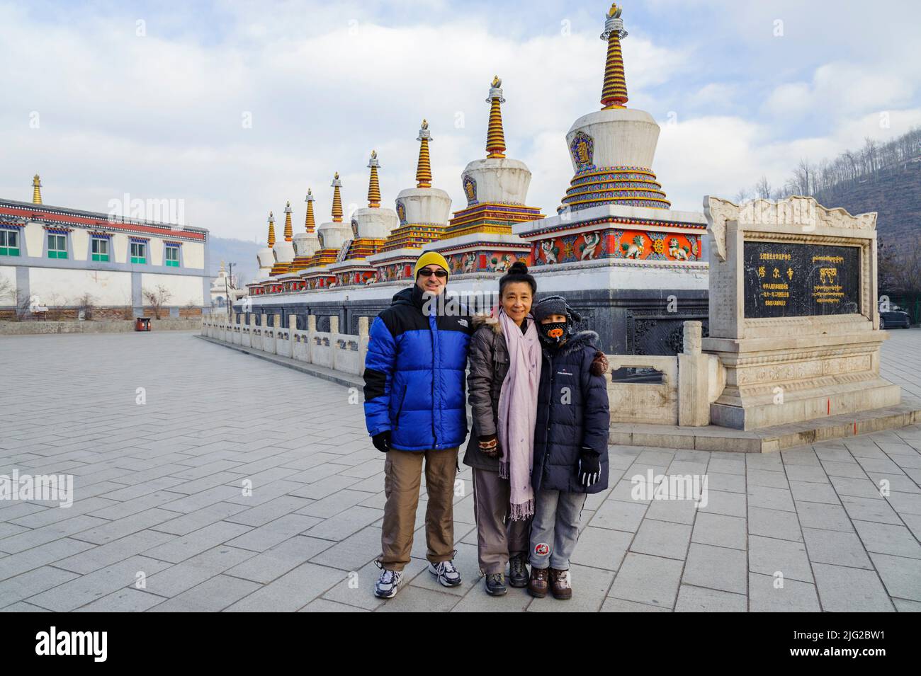 A family at the entrance of Ta'Er Monastery in front of Eight Stupas ...