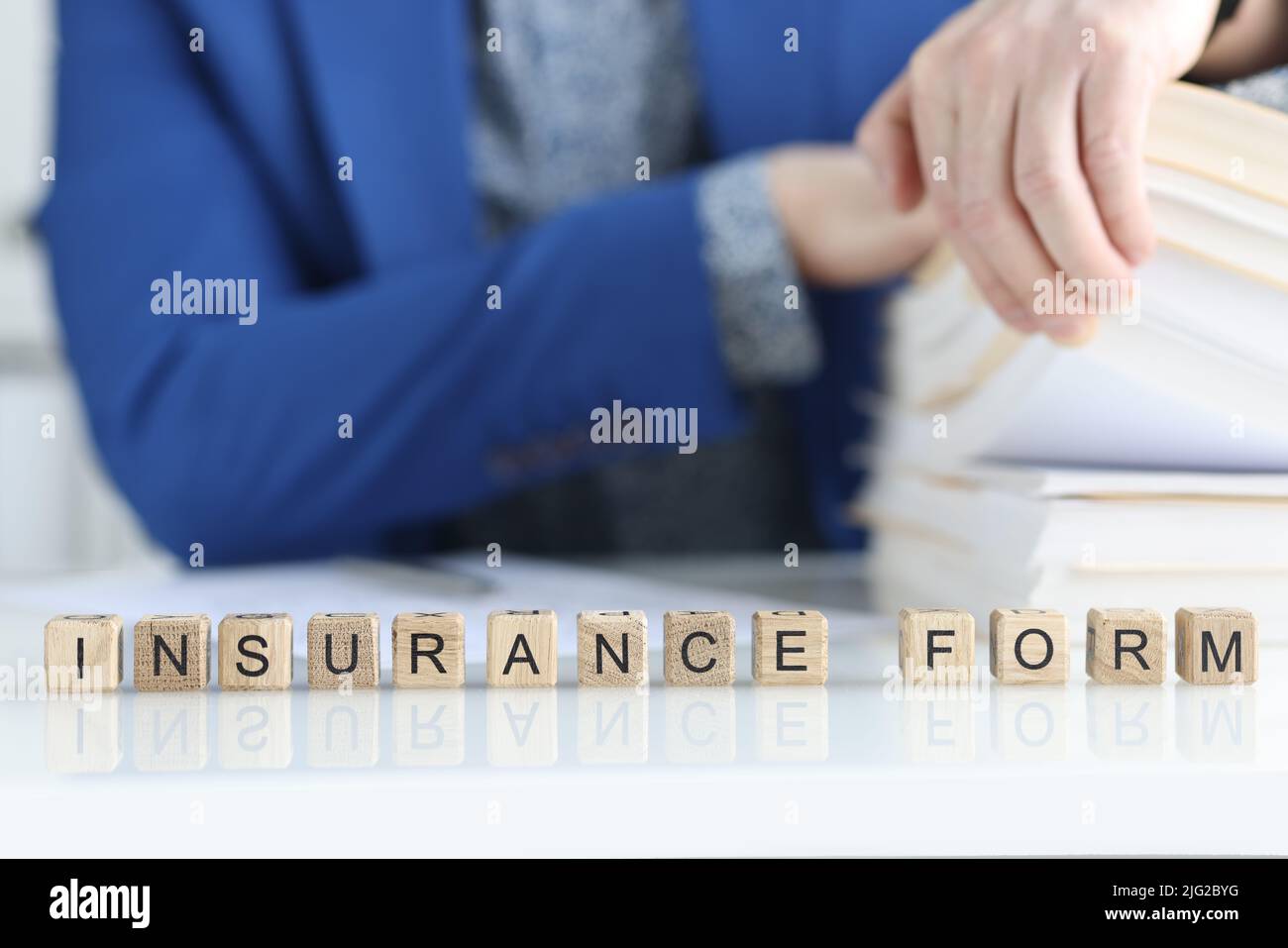 Man with insurance claim form, word collected of wooden cubes Stock ...