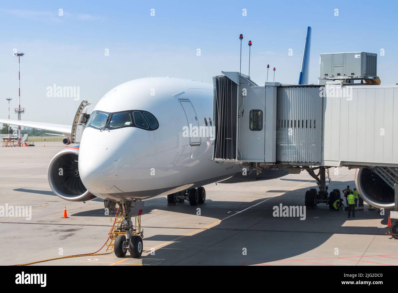 White wide body passenger airplane at the boarding bridge Stock Photo ...