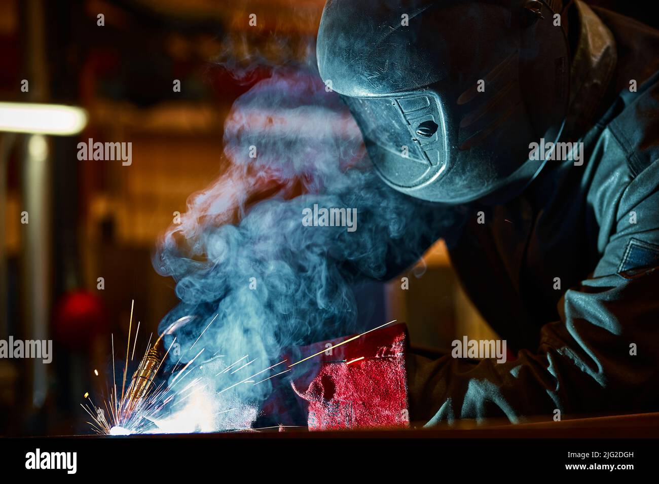 Employee in protective mask and gloves welds metal carcass Stock Photo ...