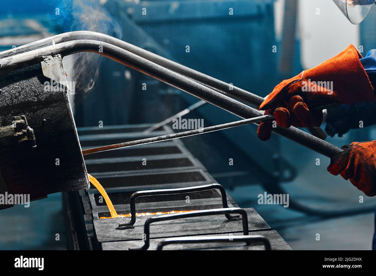 Pouring red liquid silver from bucket in induction oven Stock Photo - Alamy