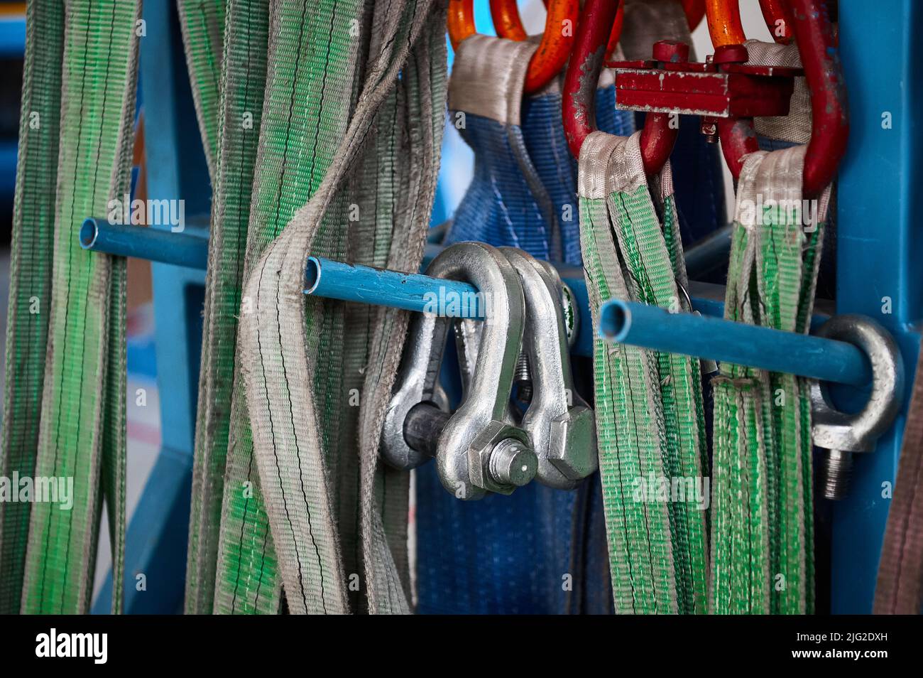 Rigging equipment with strops hangs on rack in warehouse Stock Photo ...