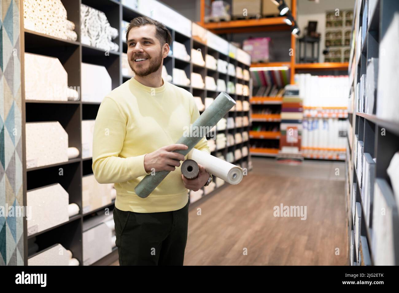 happy customer with paper wallpaper in hands at hardware store Stock ...