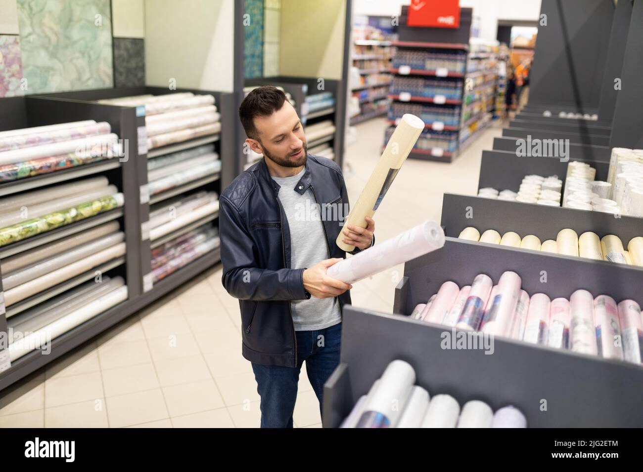 a male customer in a decoration materials store chooses paper ...