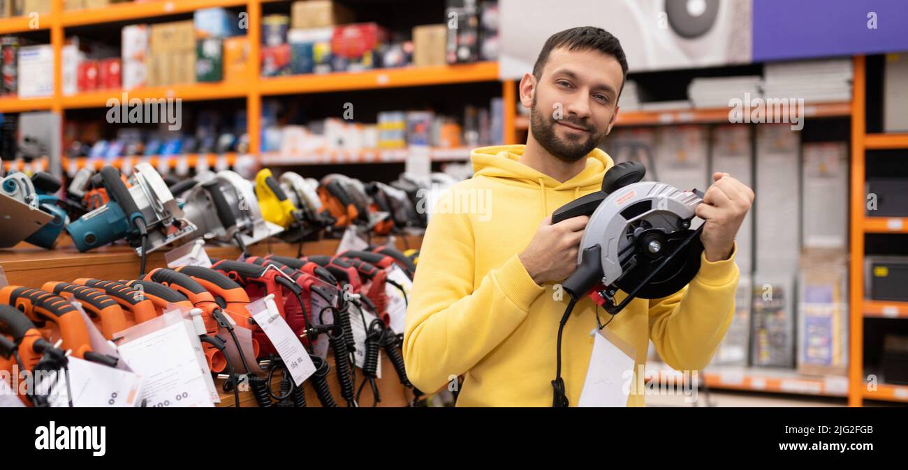 a young man in a hardware store in the tool department embracing a ...