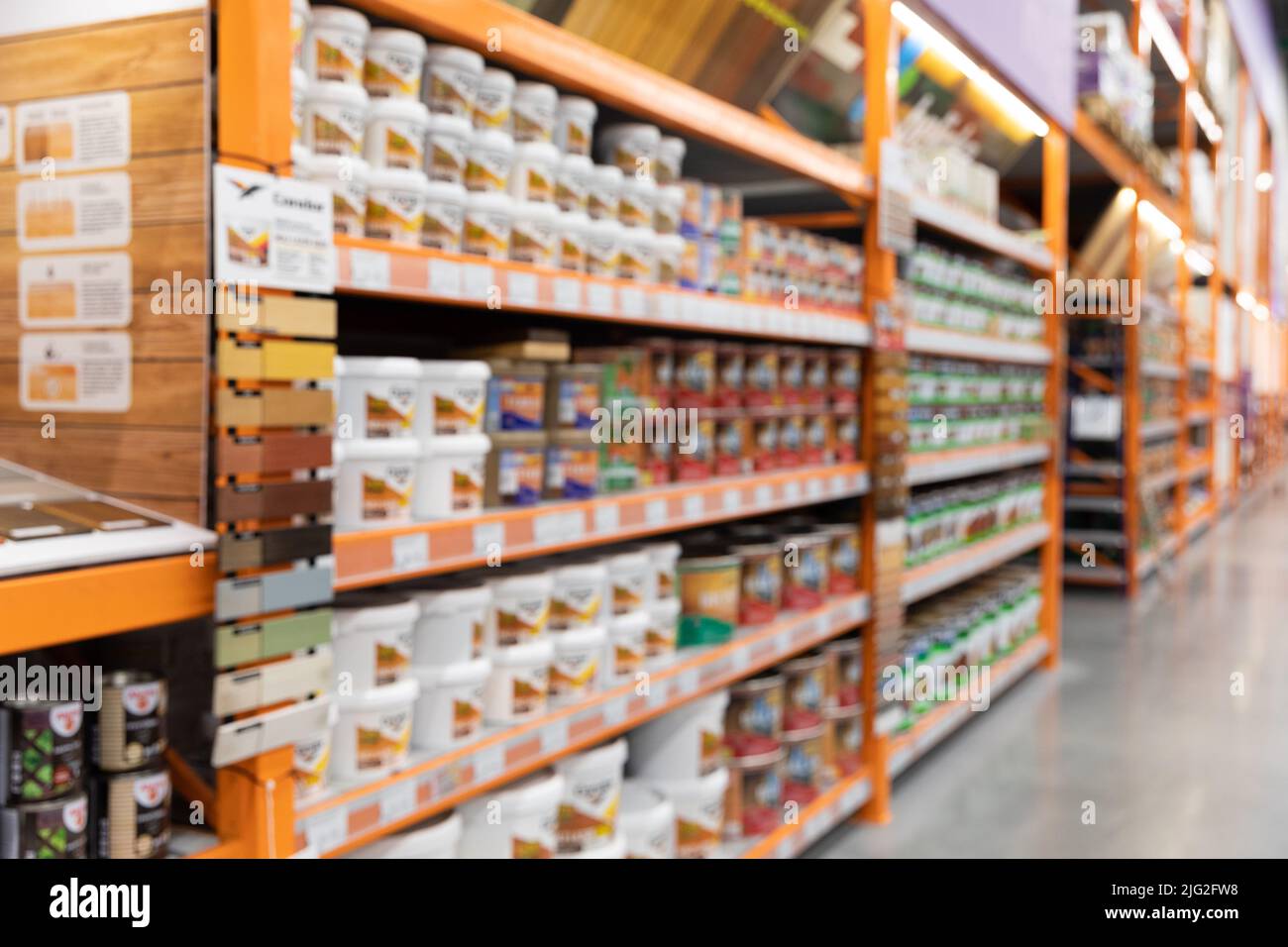racks with paints and enamels in a hardware store, blurred photo for ...